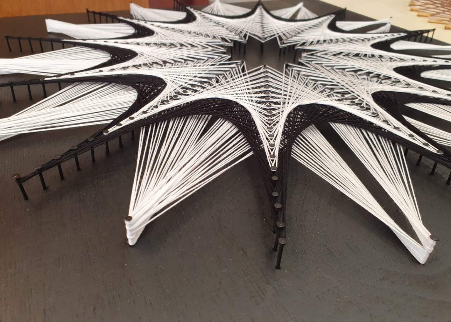 Fadenbild String Art Stern schwarz-weiß auf schwarzem Hintergrund » M-DEKO